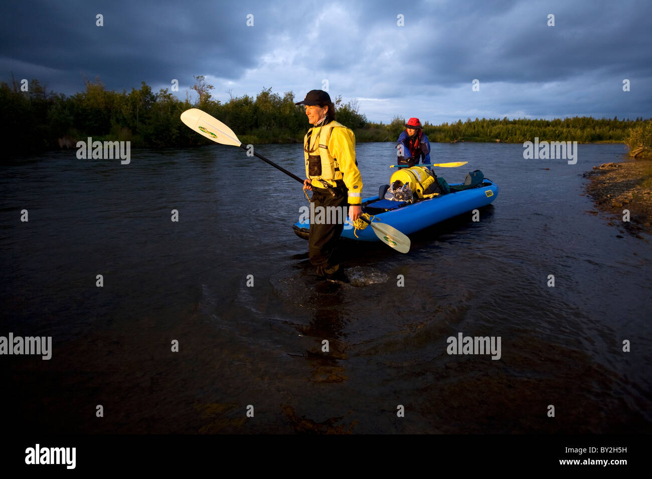 Two kayakers portage their kayak in the Alaska wilderness Stock Photo ...