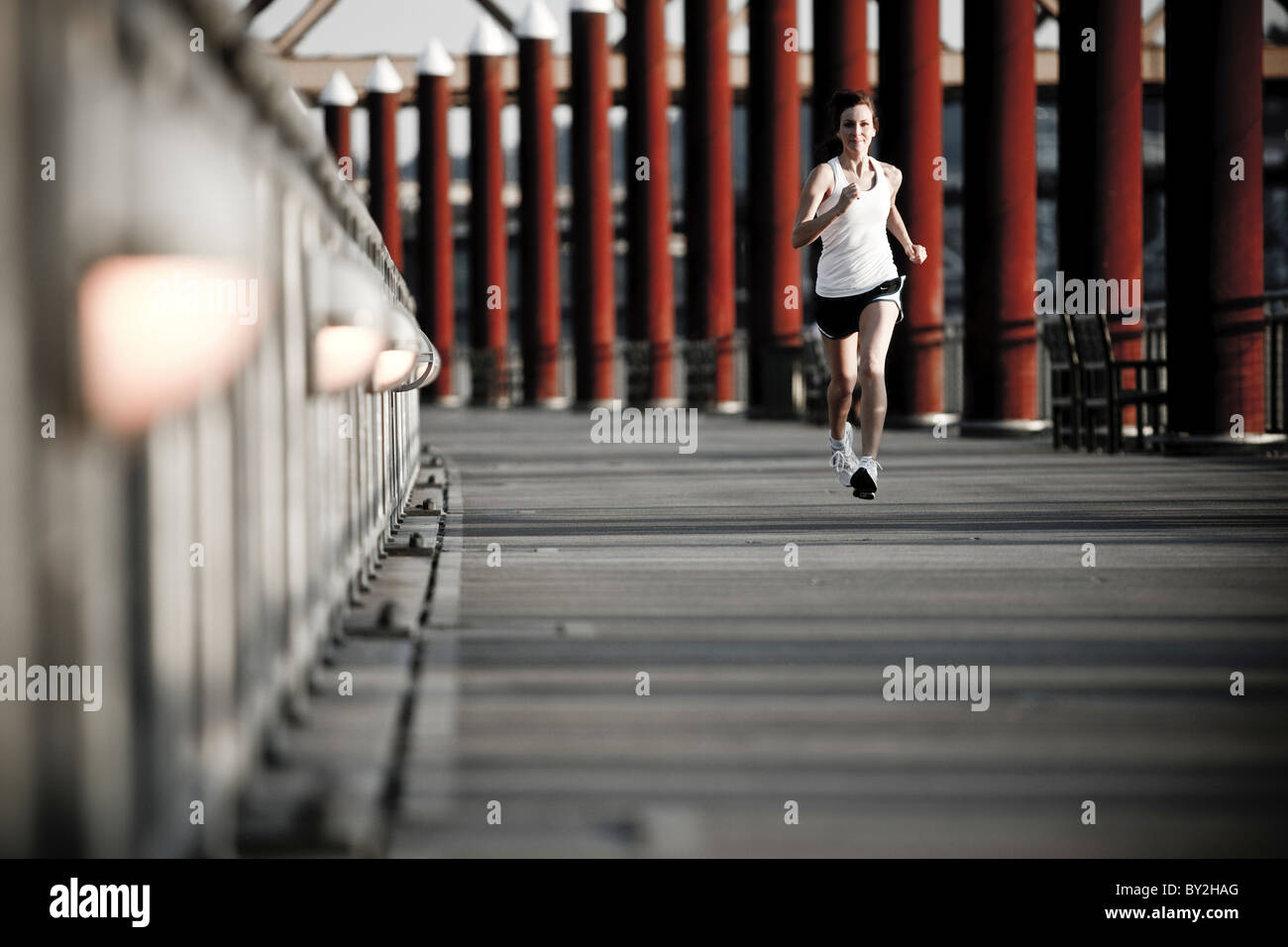 A woman running a path along the waterfront Stock Photo - Alamy