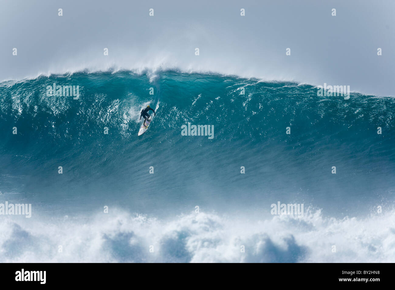 A young man surfing a huge wave at Pipeline, on the north shore of Oahu ...
