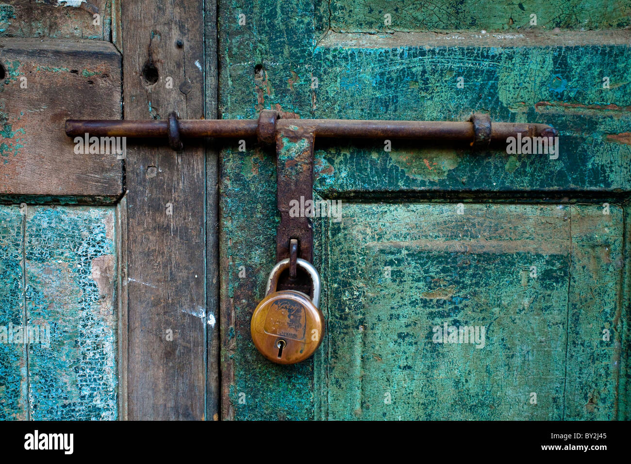 A close up photo of a brass lock on an old blue green shop door Stock ...