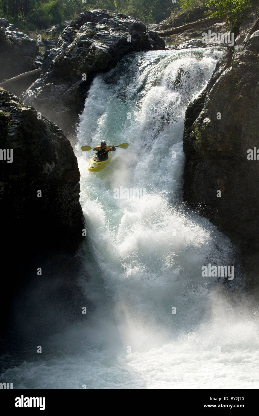 Young kayaker dropping into a large rapid / waterfall in the jungle in ...