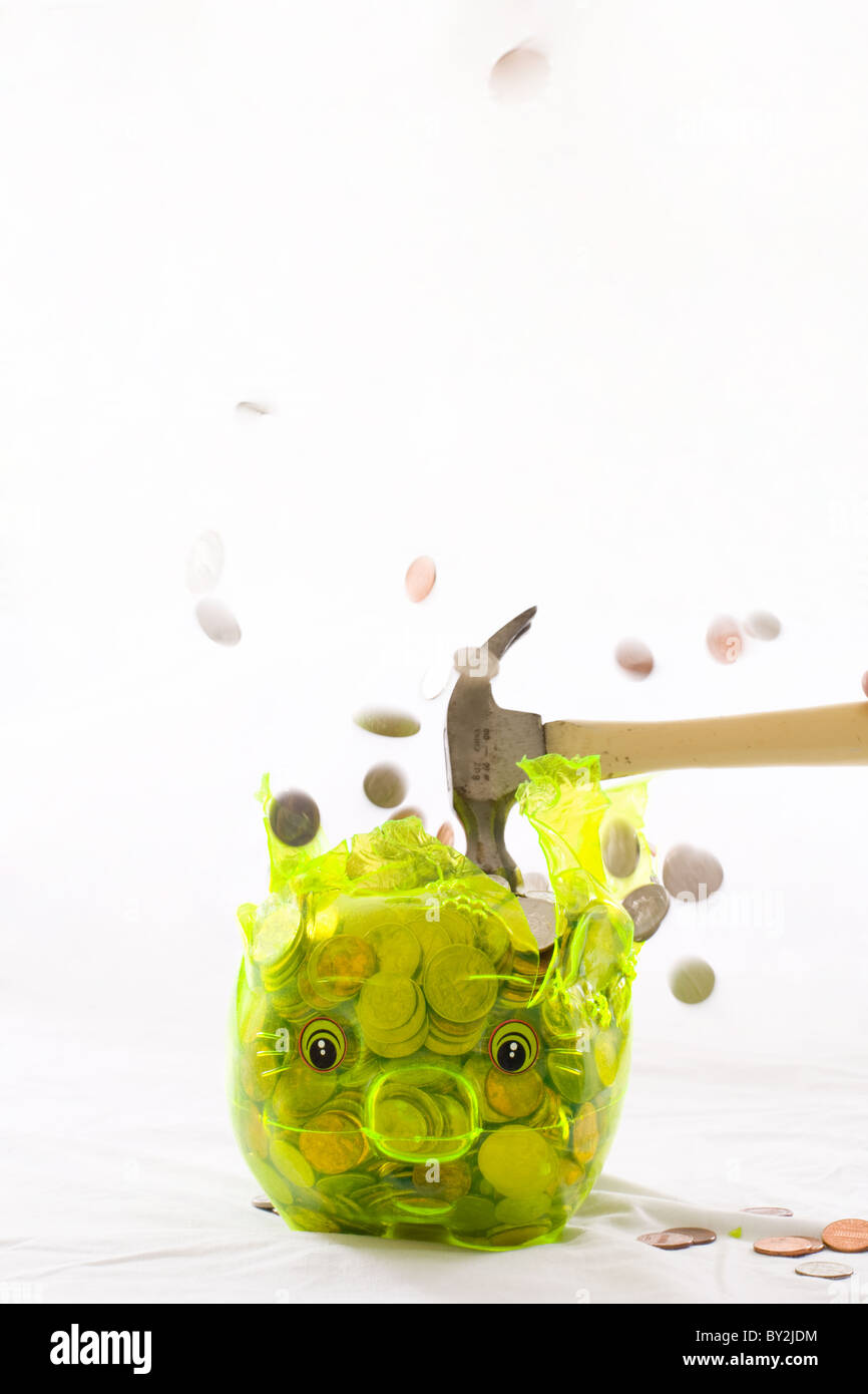 Hammer breaking open piggy bank and coins flying Stock Photo - Alamy