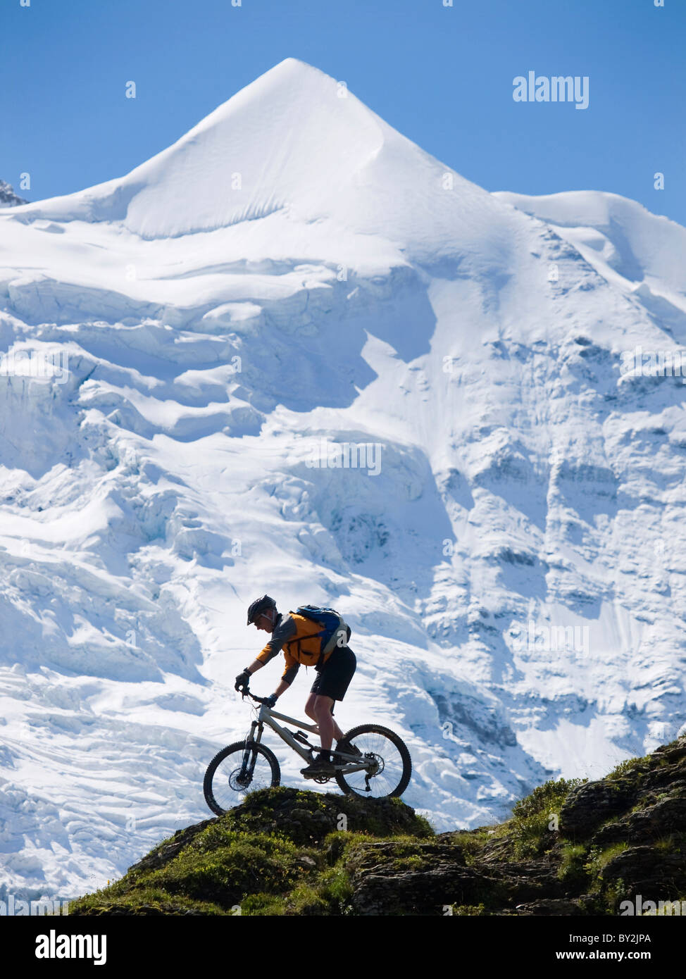 A mountain biker is balancing his bike on a steep slope near Kleine ...