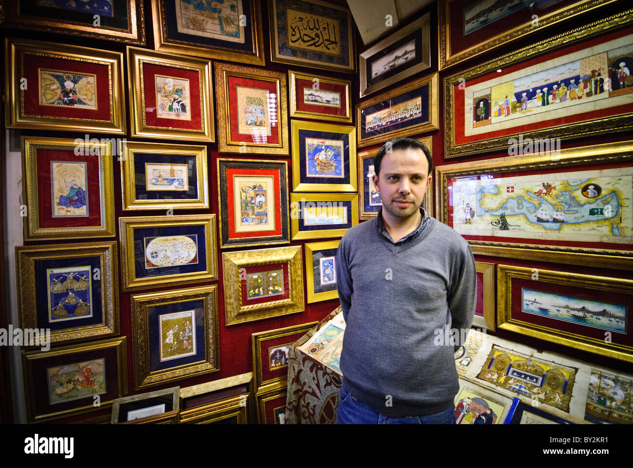 Shopkeeper poses with the illuminations and illustrations on display on ...