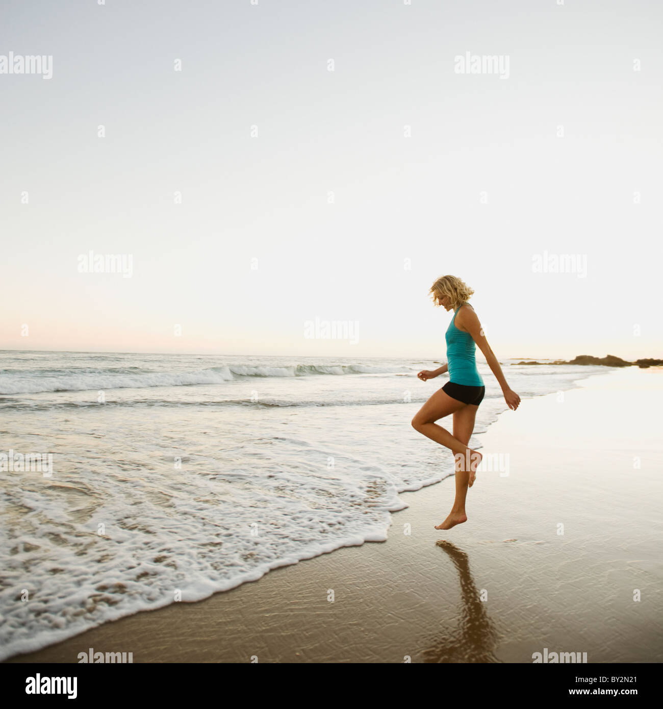 Portrait of woman running on beach Stock Photo - Alamy