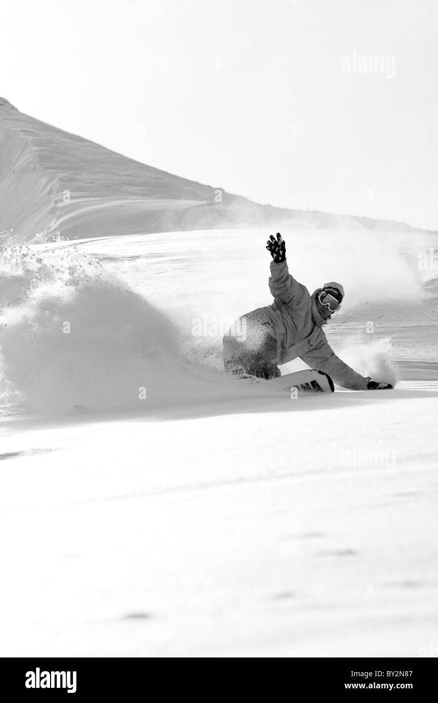 A male snowboarder makes a big powder turn at the Grand Targhee Ski ...