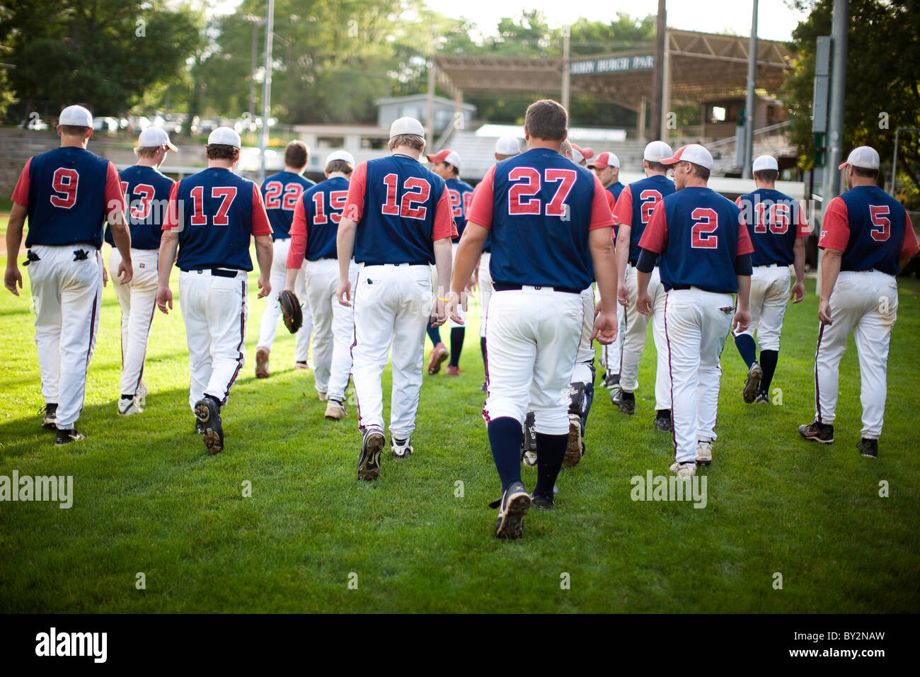 Members of a baseball team walk off the field in matching uniforms ...