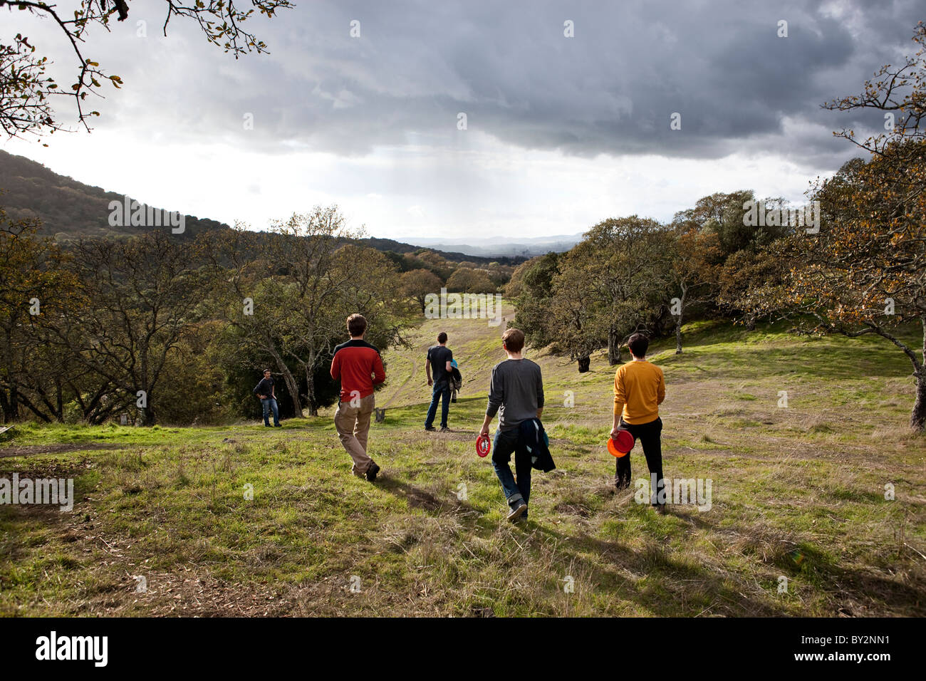 A group plays frisbee golf Stock Photo - Alamy
