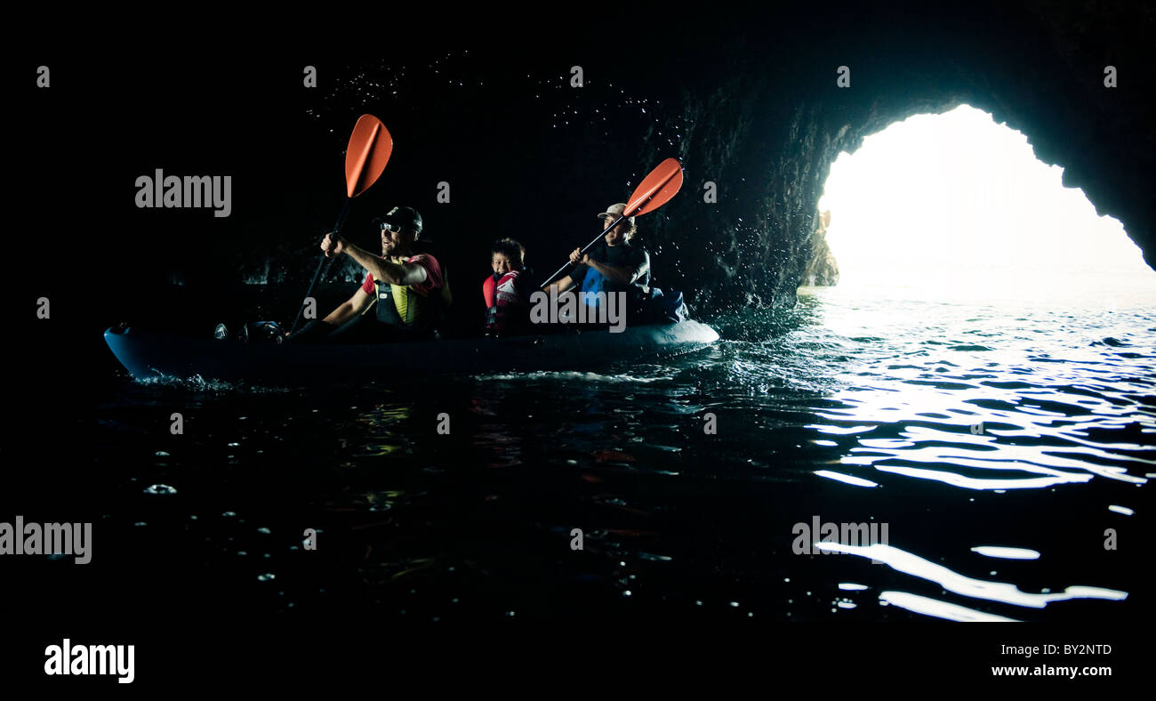 A blind adventurer leads his kayak into a sea cave on Santa Cruz Island ...