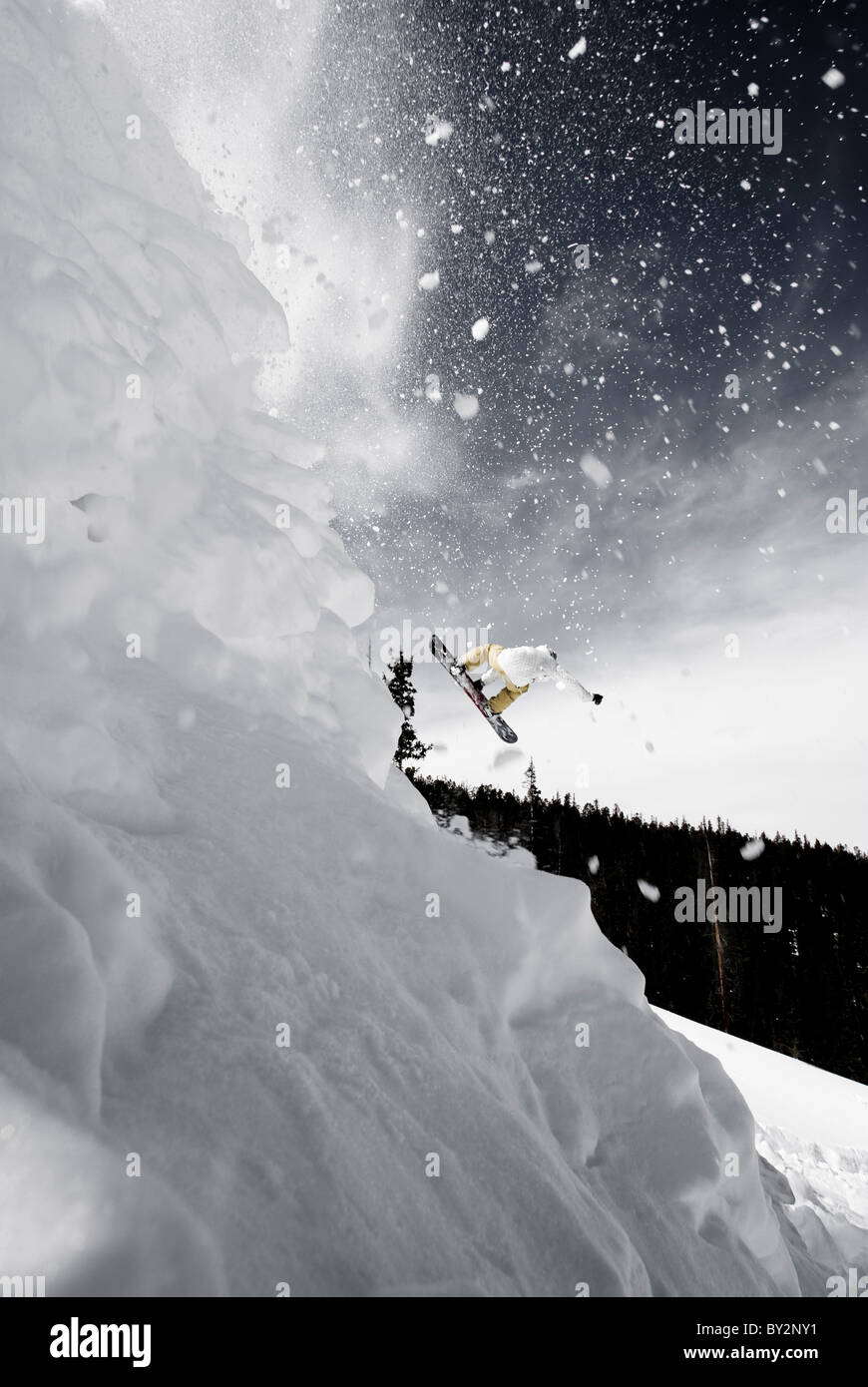 Side angle view of a snowboarder spinning off a jump in the Colorado ...