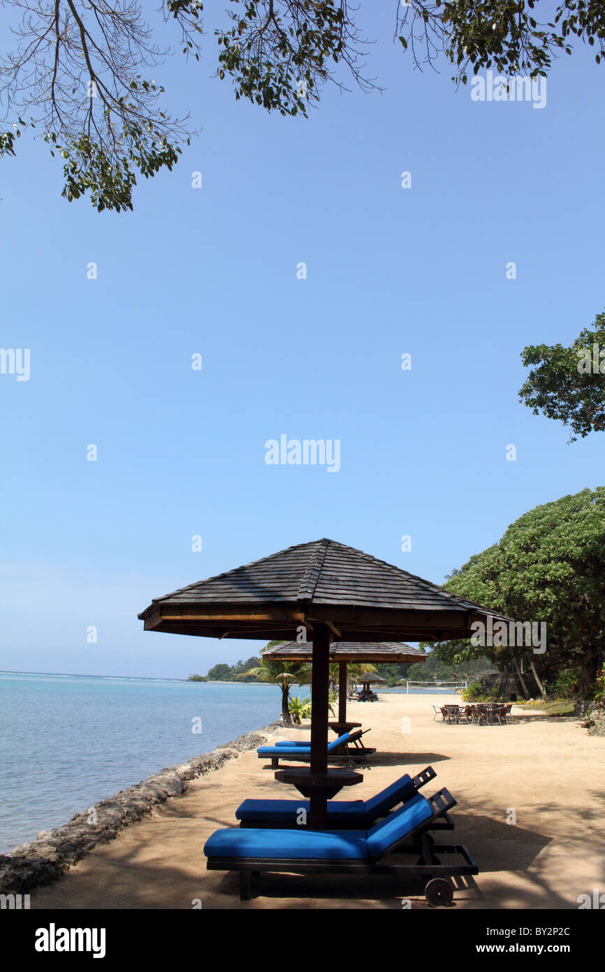 THATCH UMBRELLA AND LOUNGES ON TROPICAL ISLAND BLUE SKY BACKGROUND BDA ...