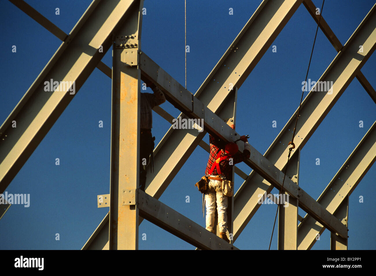 Construction workers on steel beams at commercial construction site in ...