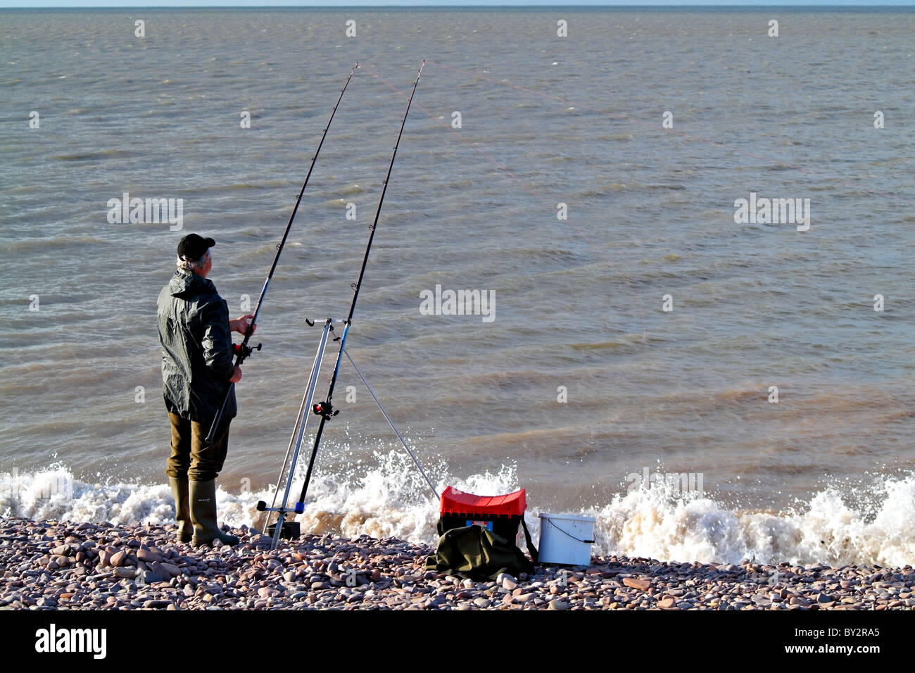 sea angler fishing from the beach Stock Photo - Alamy