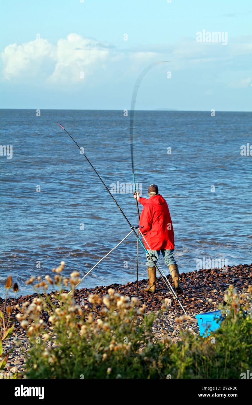 sea angler fishing from the beach Stock Photo - Alamy