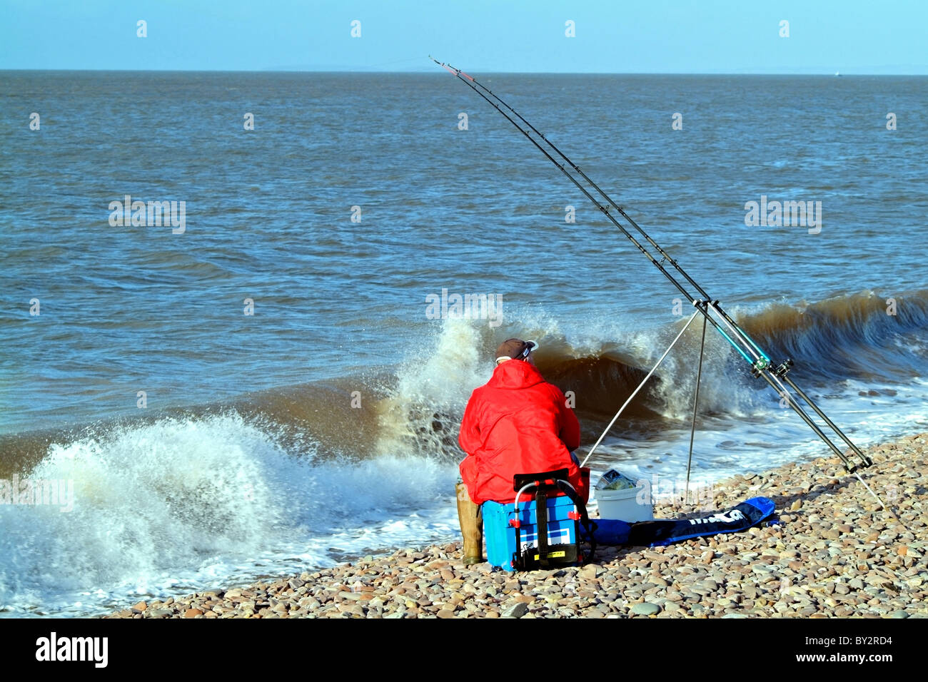 sea angler fishing from the beach Stock Photo - Alamy