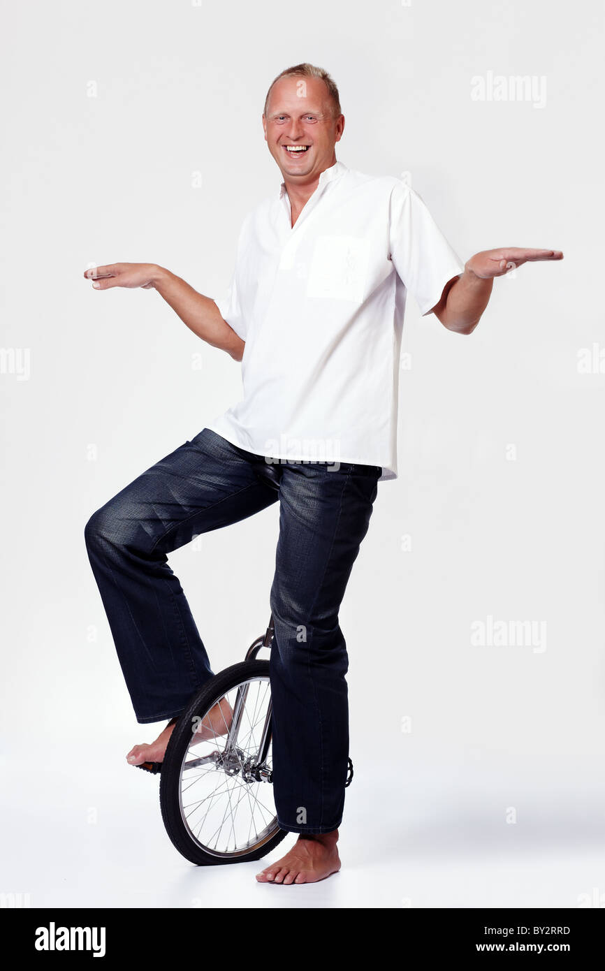 Man riding a unicycle Stock Photo - Alamy
