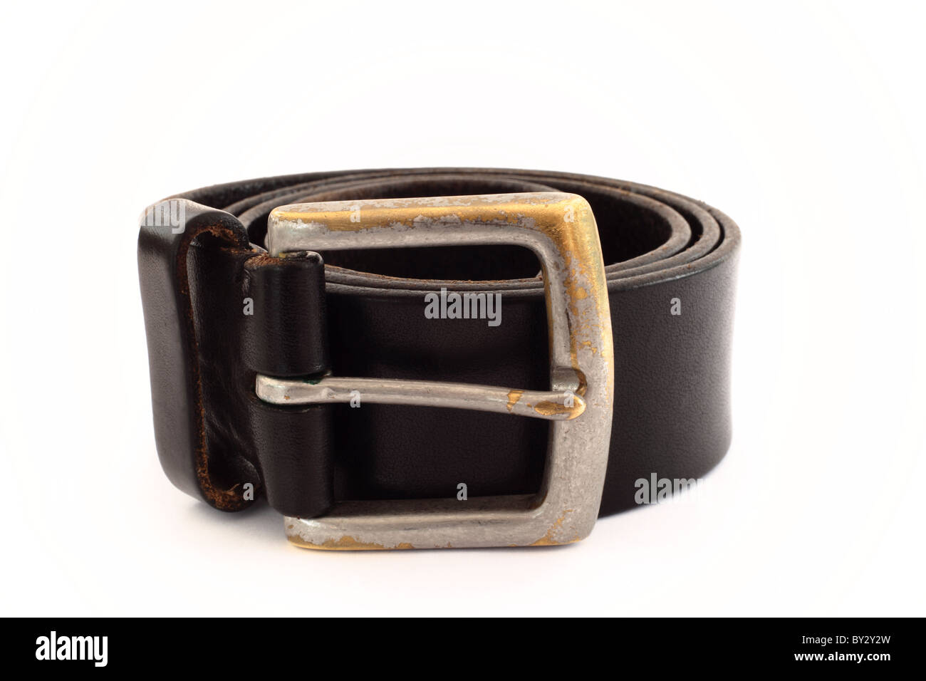 Coiled leather belt with a worn belt buckle on a white background Stock ...