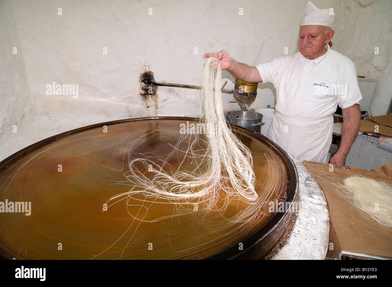 Making Kataifi. stringy filo pastry, in the traditional way on a ...