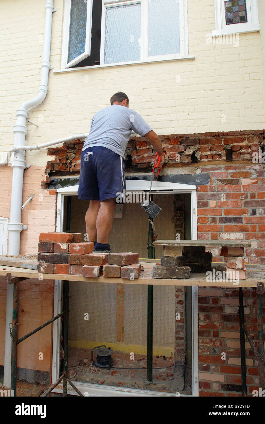 Man on platform bricklaying at house UK Stock Photo - Alamy