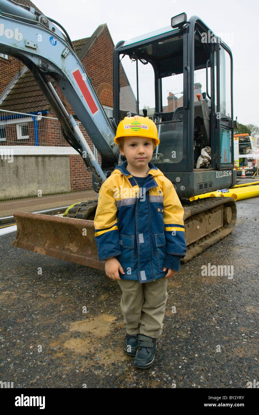 Boy standing near mini digger Stock Photo - Alamy