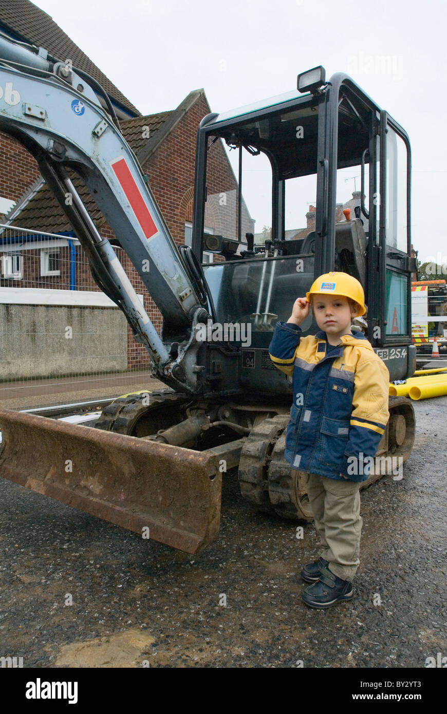 Boy standing near mini digger Stock Photo - Alamy