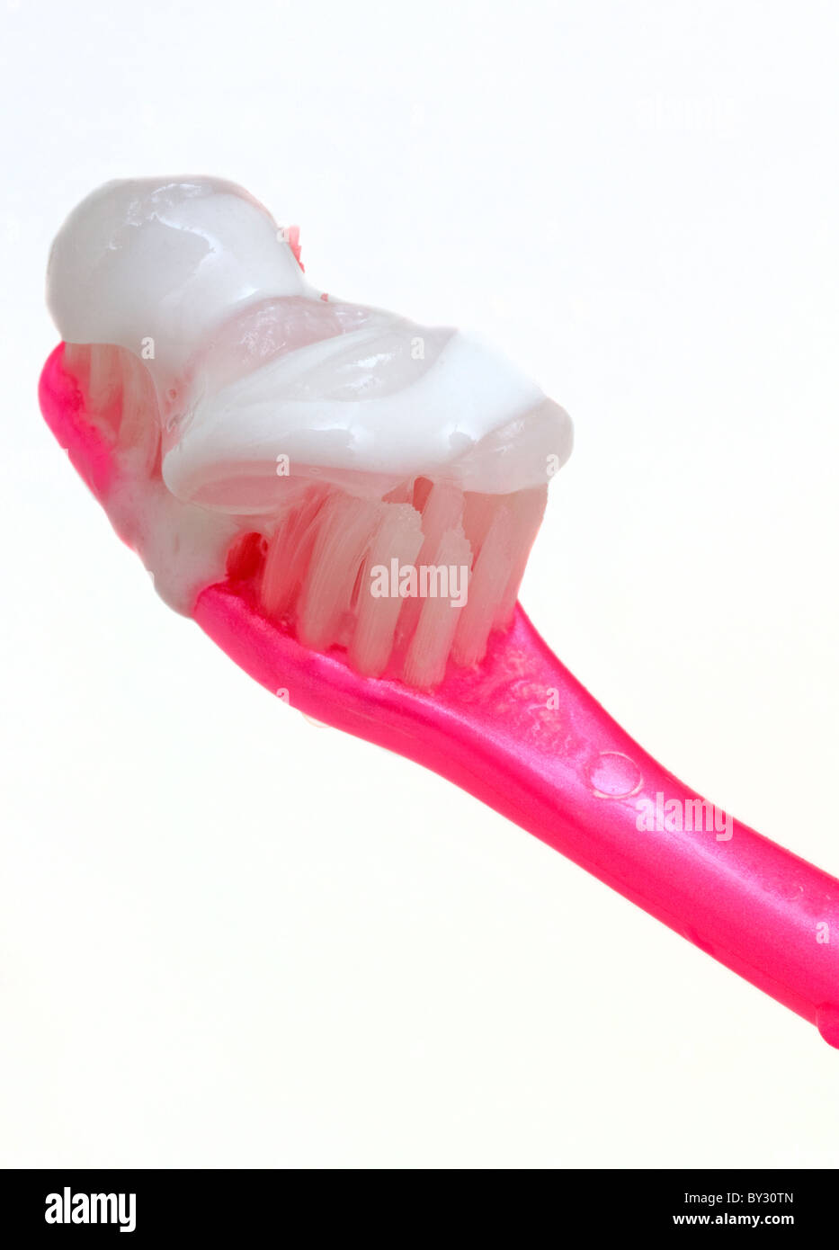 Toothpaste on a pink toothbrush Stock Photo - Alamy