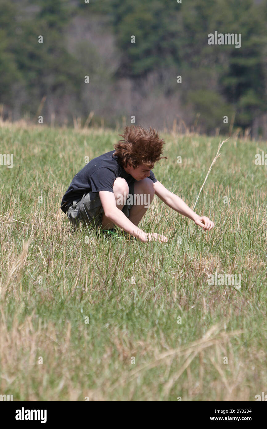 Teen boy rolling down hill Stock Photo - Alamy