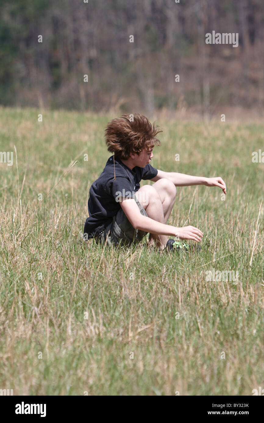 Teen boy rolling down hill Stock Photo - Alamy