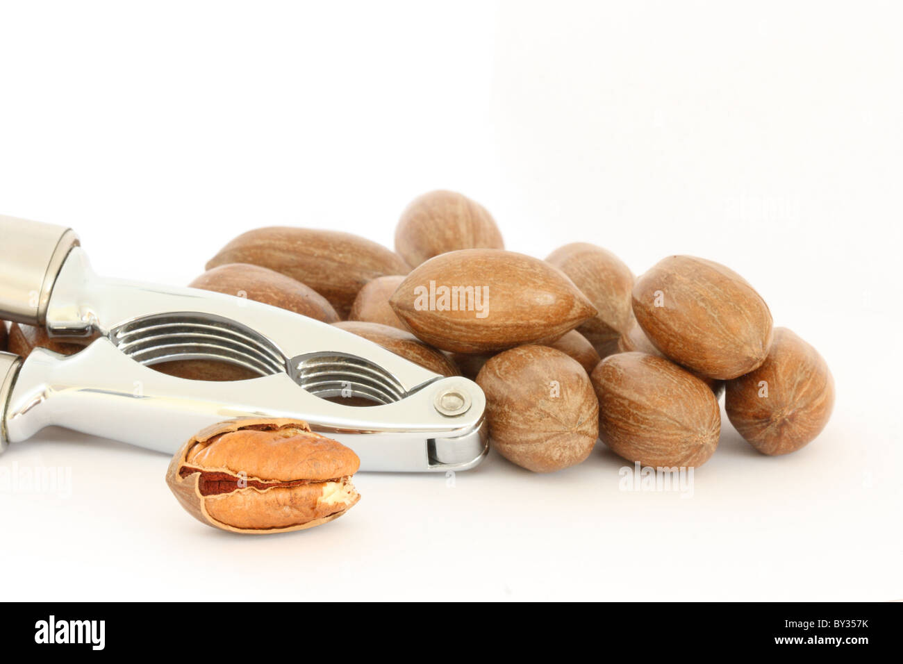 Detail view of pecan nuts and nut-cracker on white background Stock ...