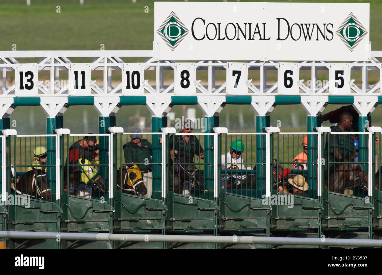 Jockeys and horses at starting gate at Colonial Downs racetrack, New ...