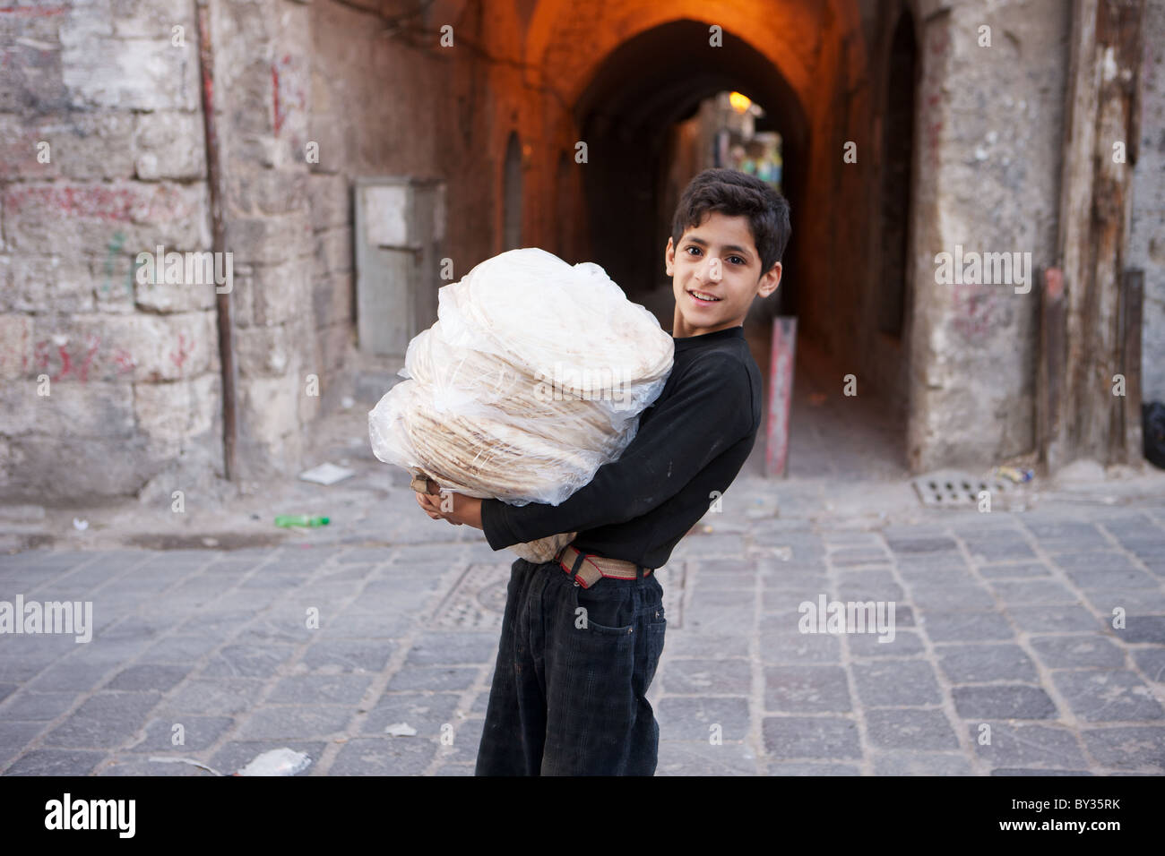 Syrian delivery boy carrying fresh bread outside a bakery in Old City ...