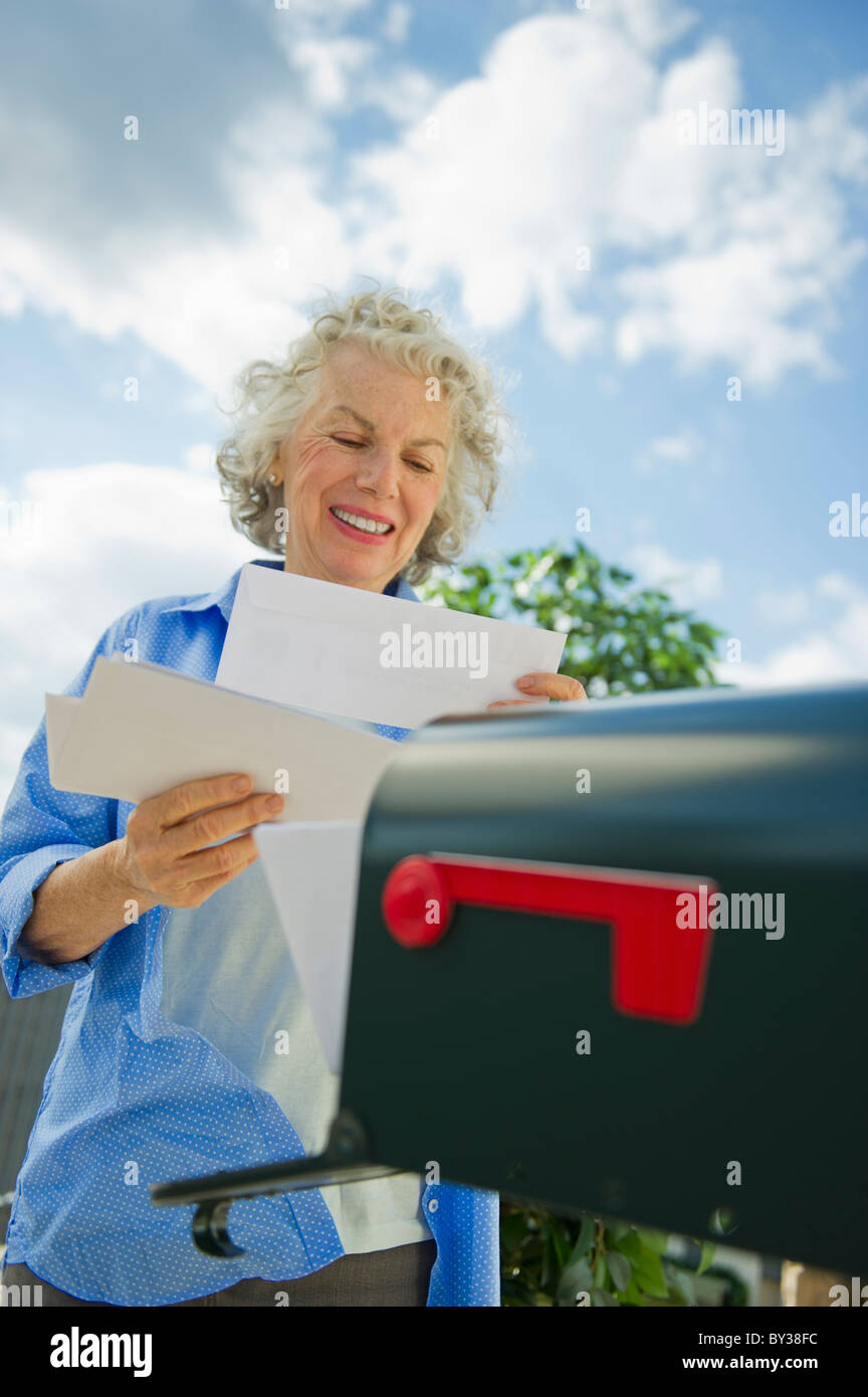 USA, New Jersey, Jersey City, Senior woman checking mail at mailbox ...