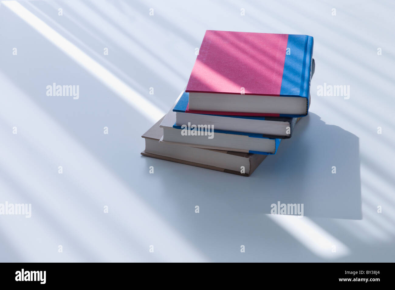 Sunlight on stacked books Stock Photo - Alamy