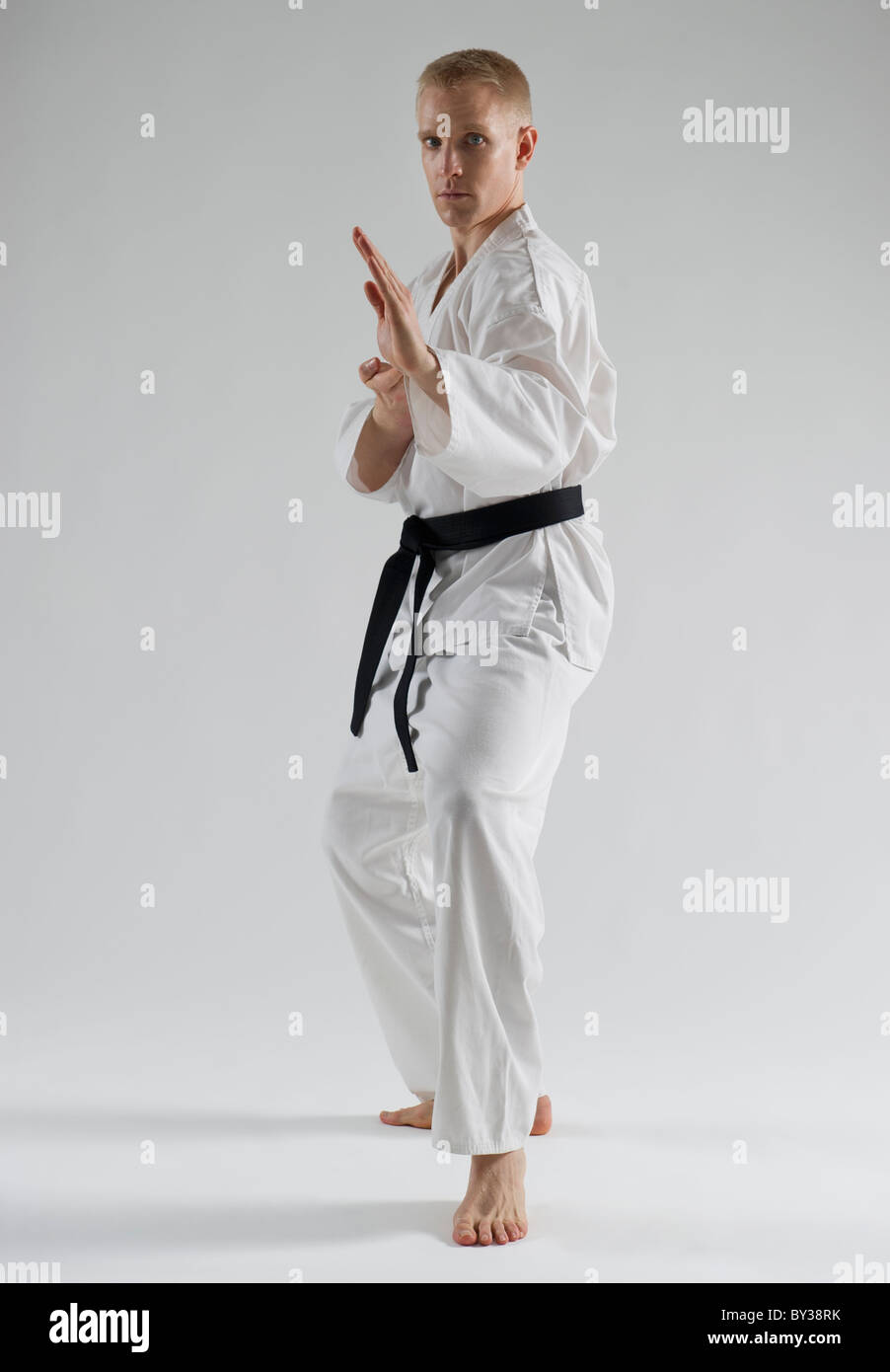 Young man performing karate stance on white background Stock Photo - Alamy