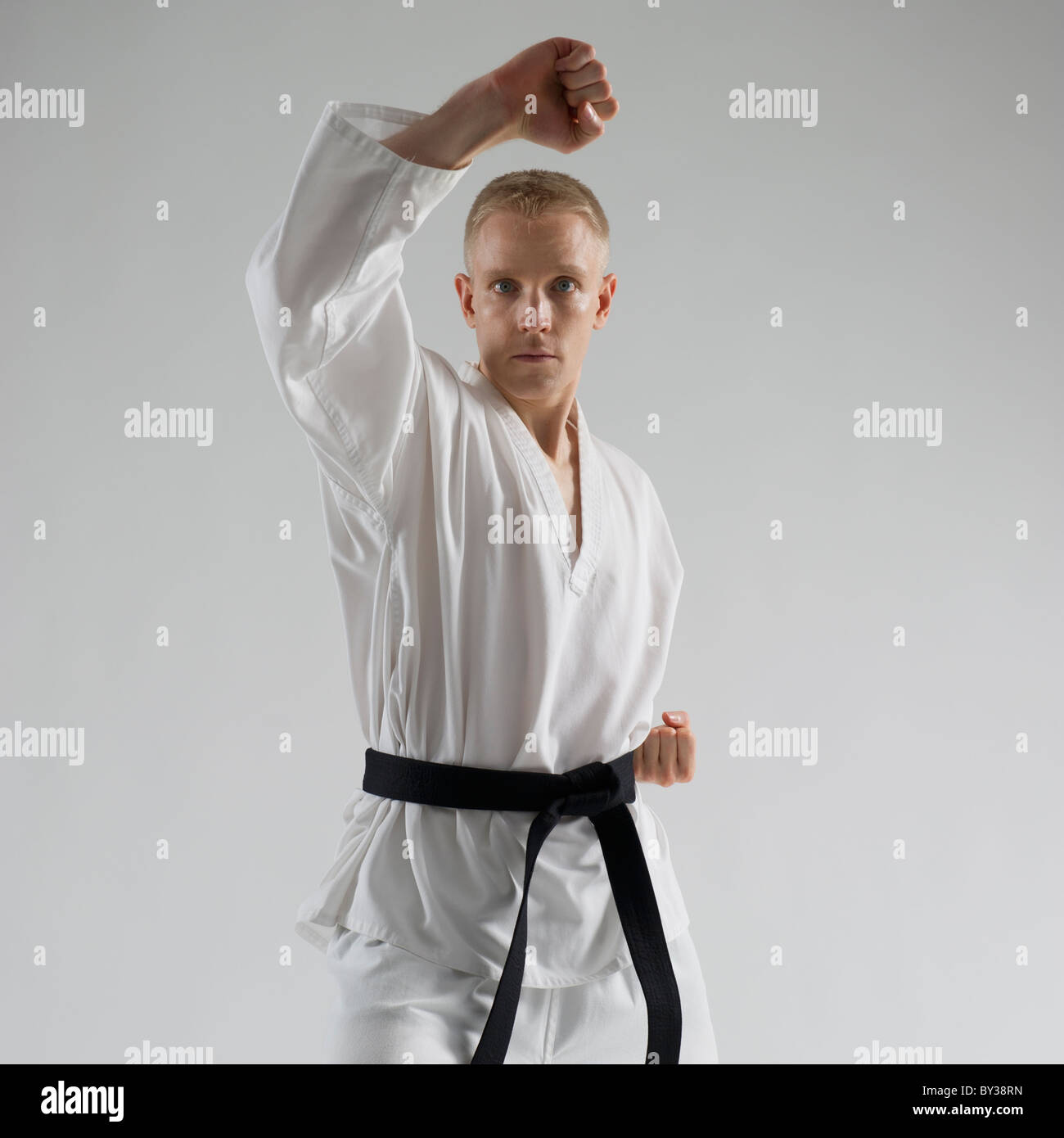 Young man performing karate stance on white background Stock Photo - Alamy