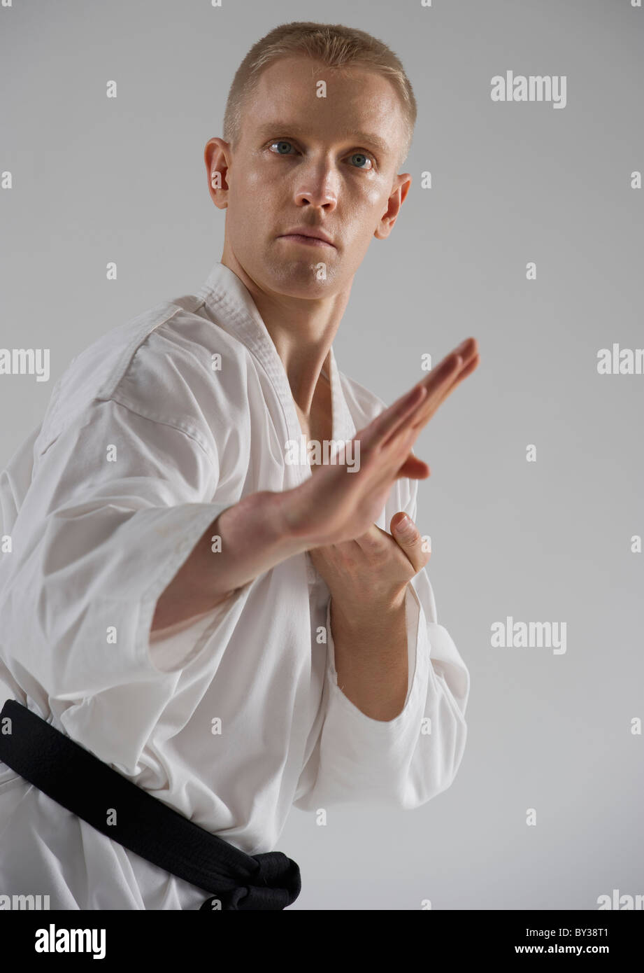 Young man performing karate stance on white background Stock Photo - Alamy