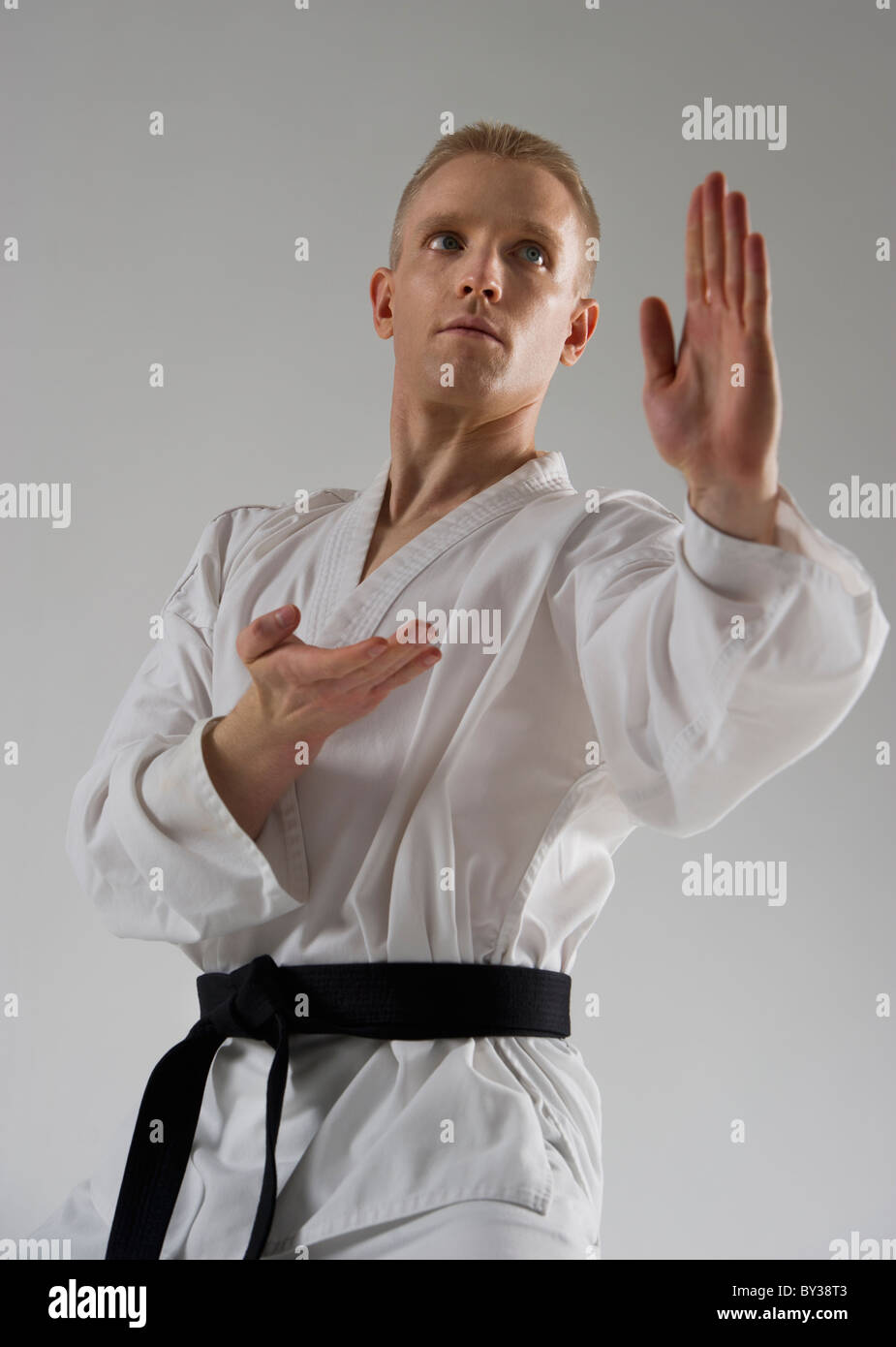 Young man performing karate stance on white background Stock Photo - Alamy