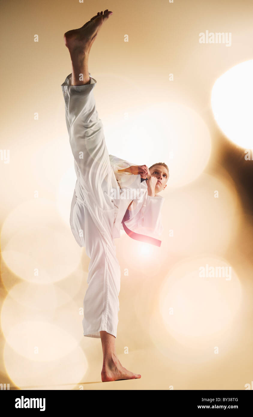 Young man performing karate kick Stock Photo - Alamy