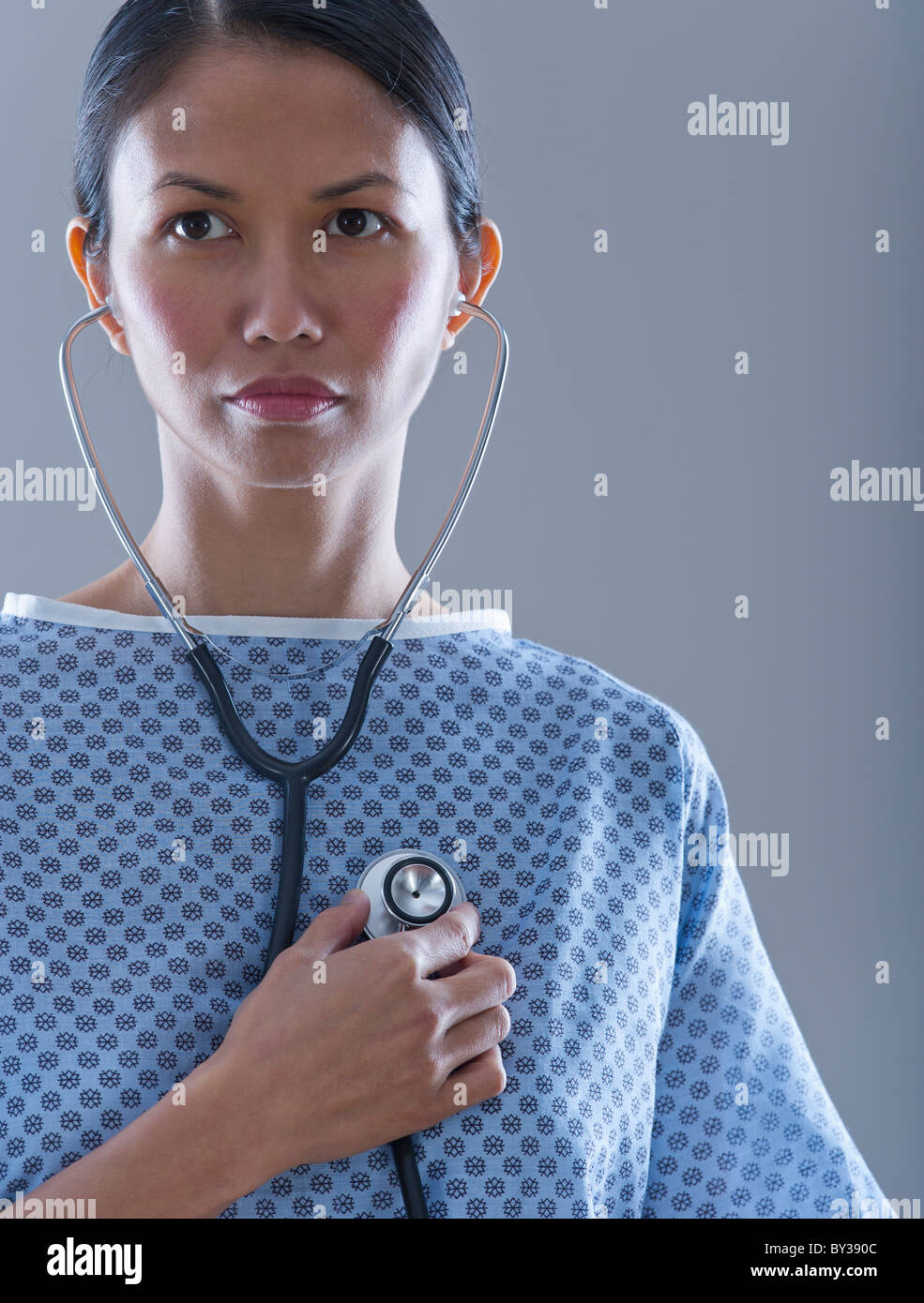 Female patient holding stethoscope to chest Stock Photo - Alamy