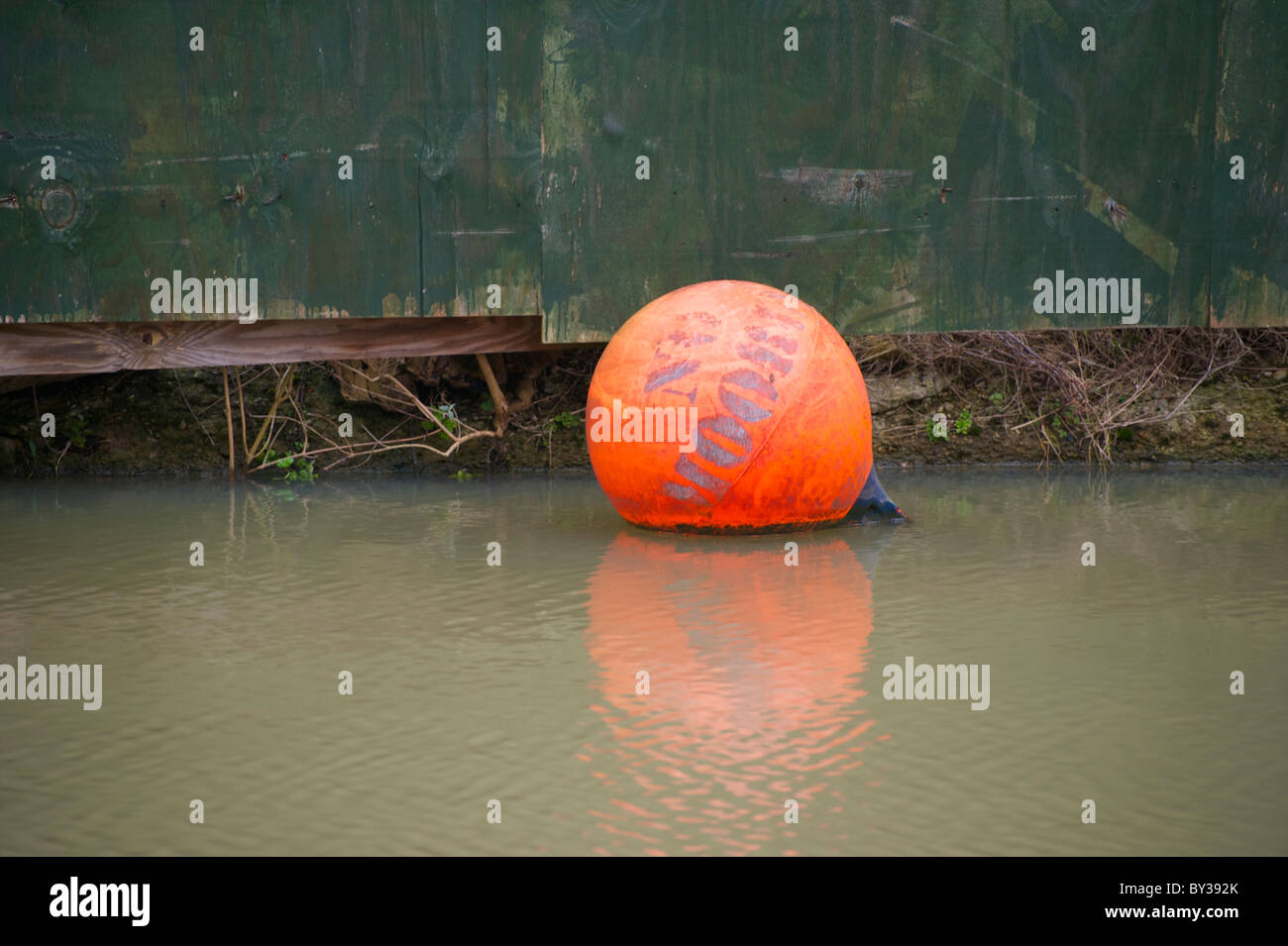 Orange buoy floating in the canal Stock Photo - Alamy