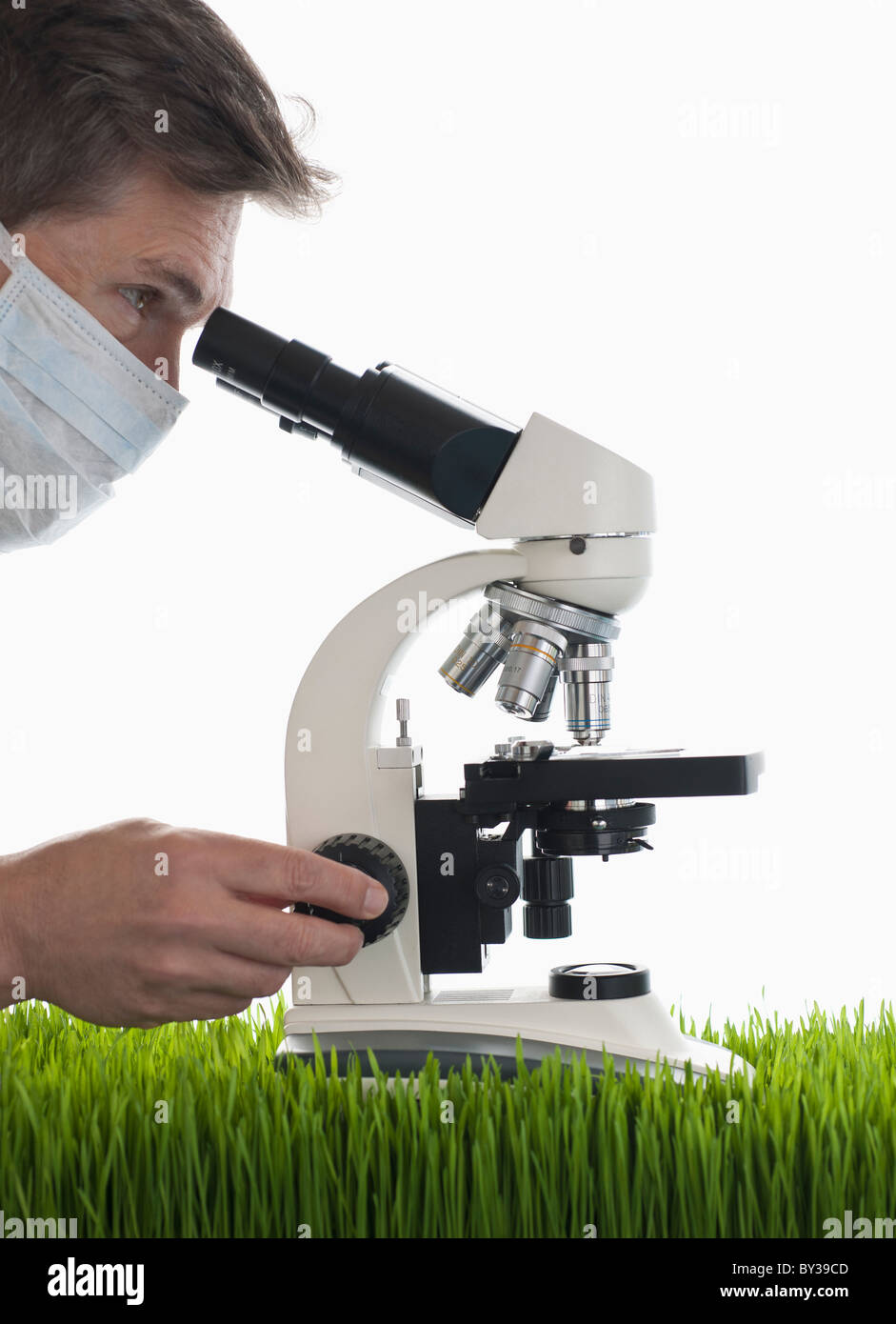 Man looking through microscope in studio Stock Photo - Alamy