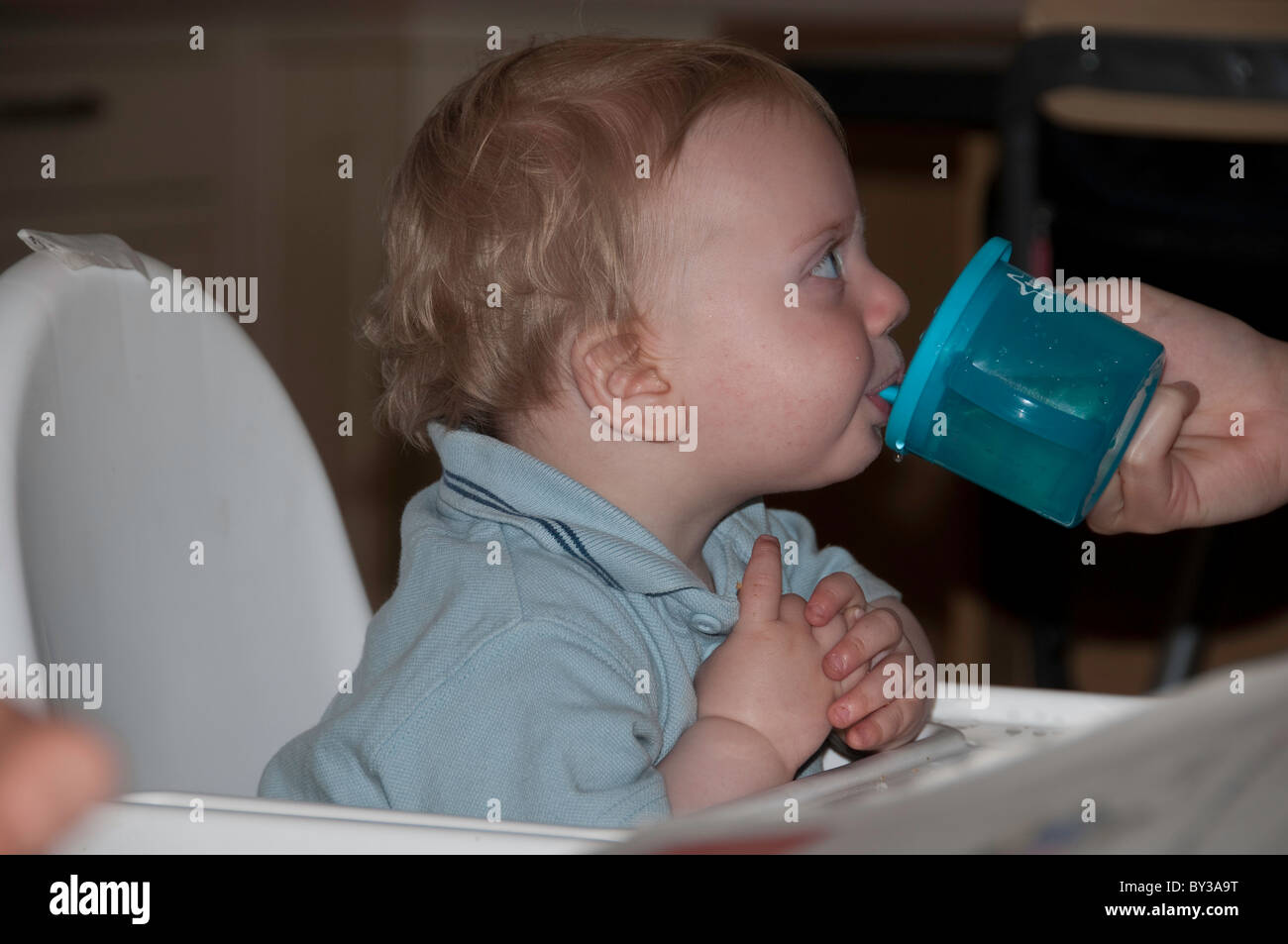 Toddler drinking out of a beaker Stock Photo - Alamy