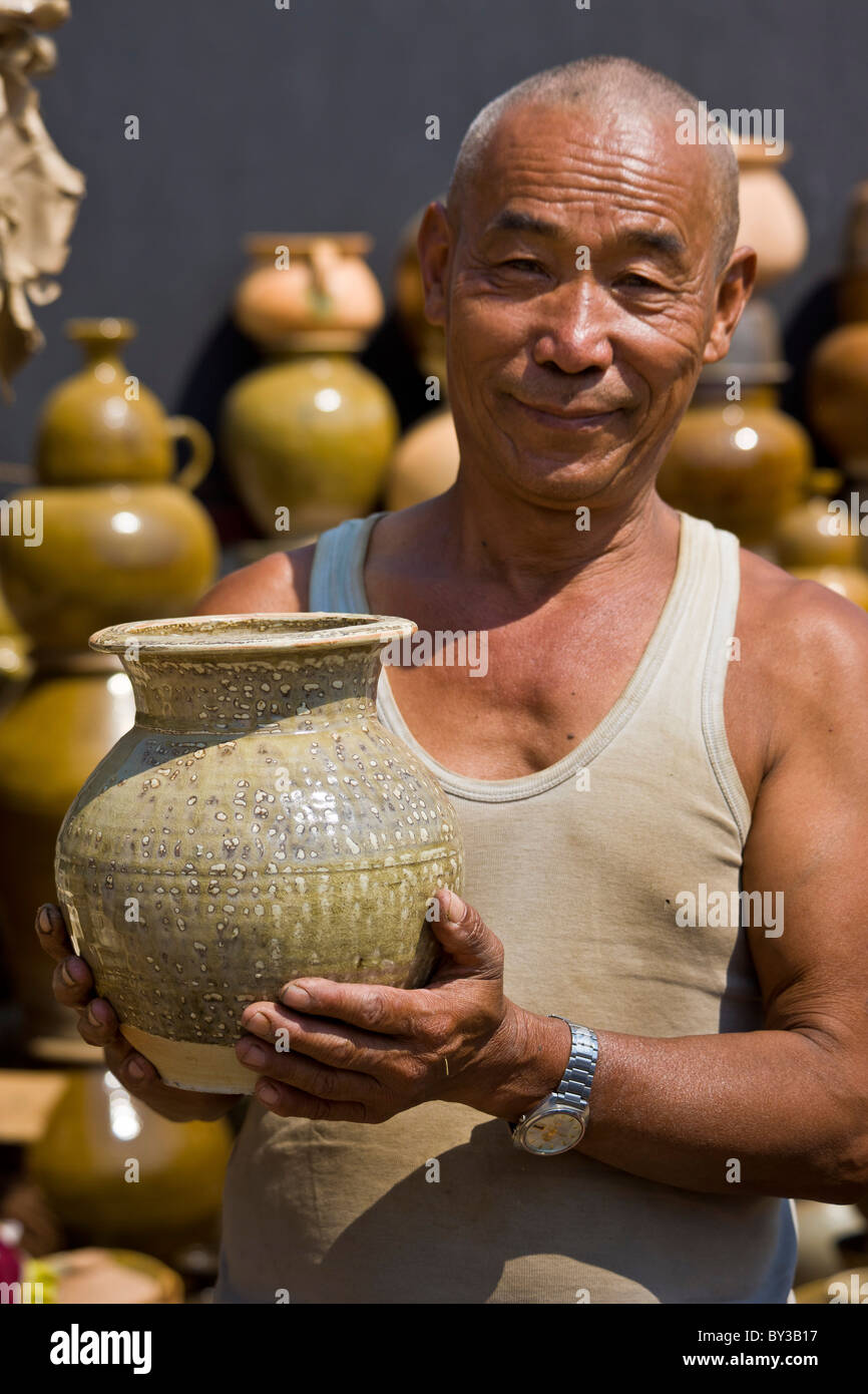 Man selling pottery in Menghai Produce Market, Yunnan Province ...