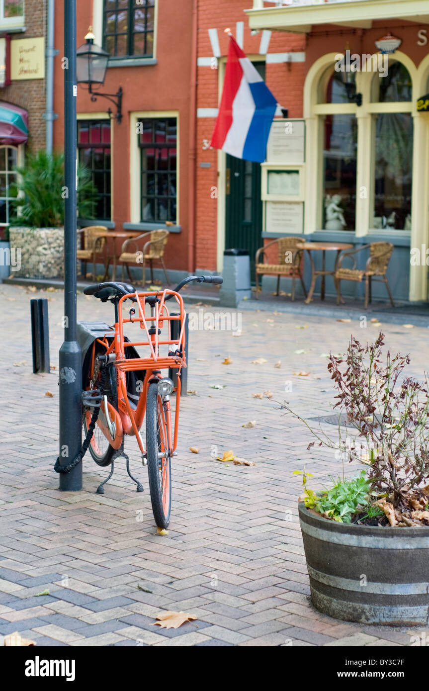 An orange bicycle outside a restaurant in the Dutch town of Delft Stock ...