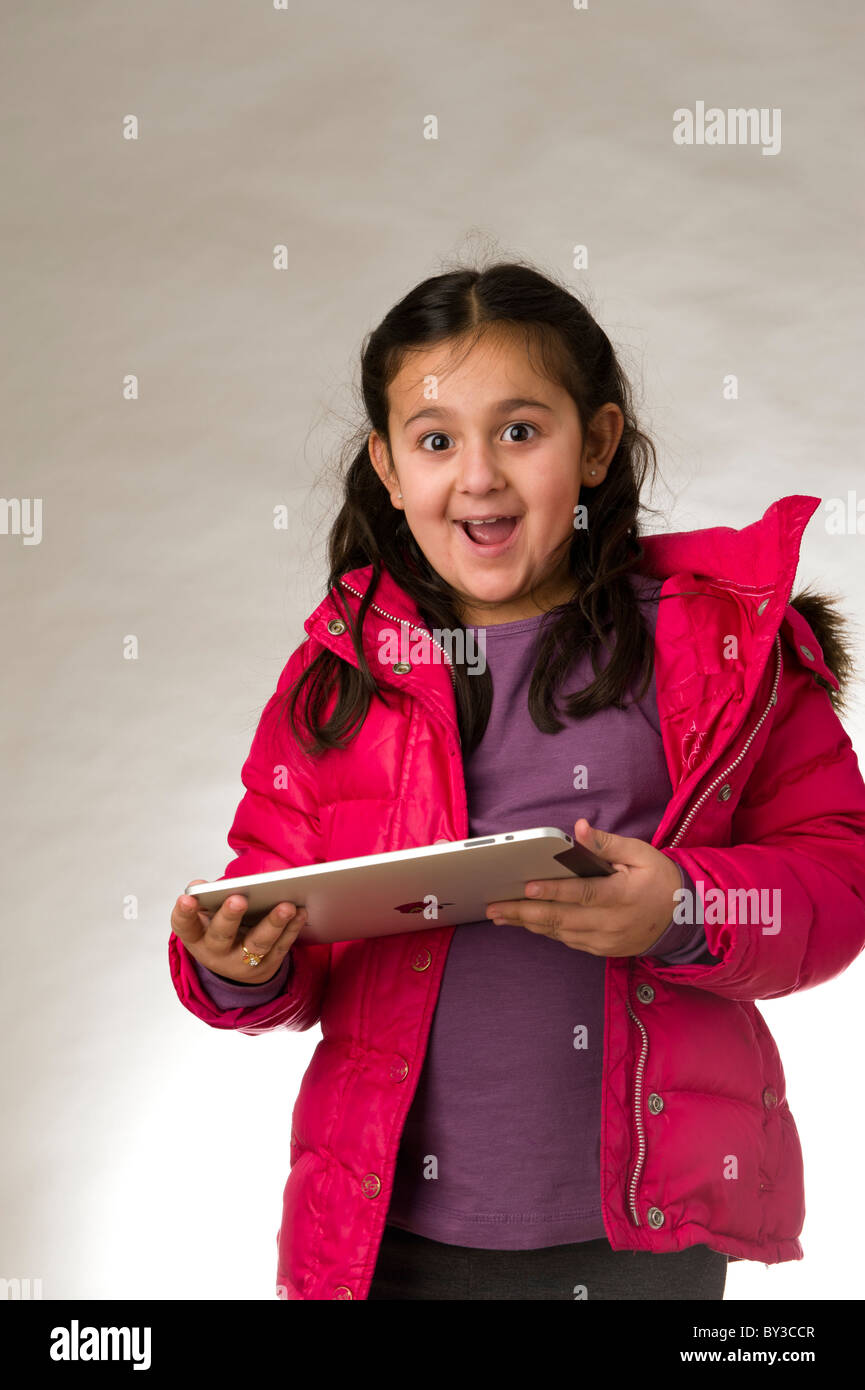 Studio shot of a young girl wearing a red coat and playing a game on ...