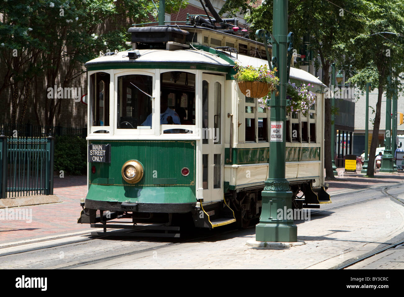 Passengers ride an electric trolley car down Main Street Stock Photo ...