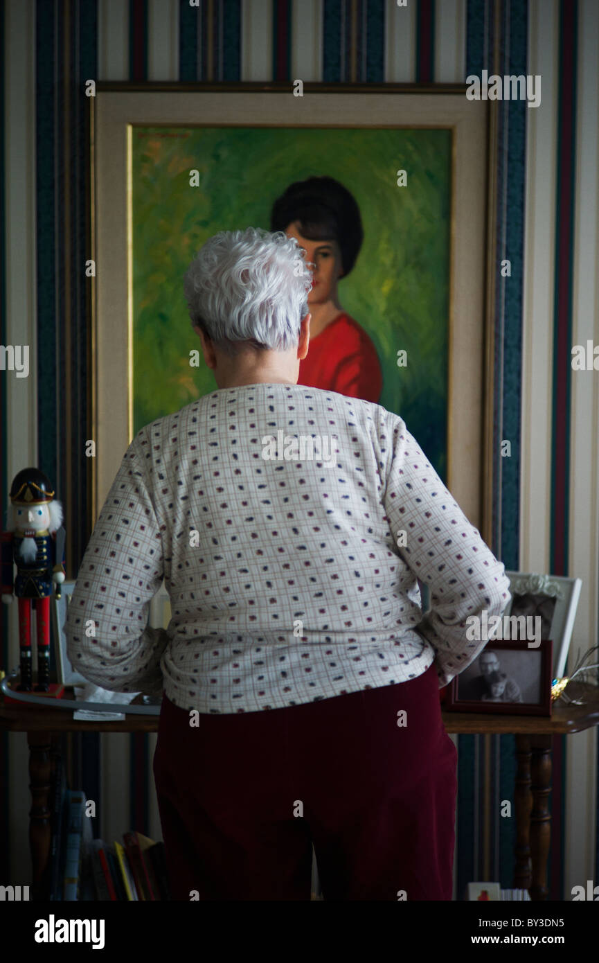 Old woman from behind as she looks at portrait of herself as a young ...