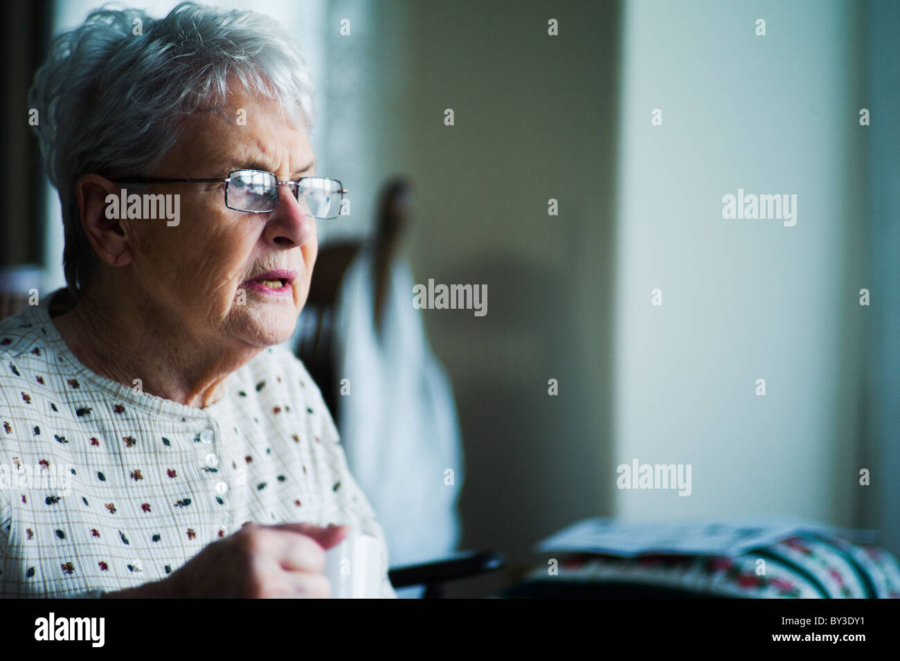 Old woman sitting in chair looking with concerned expression Stock ...