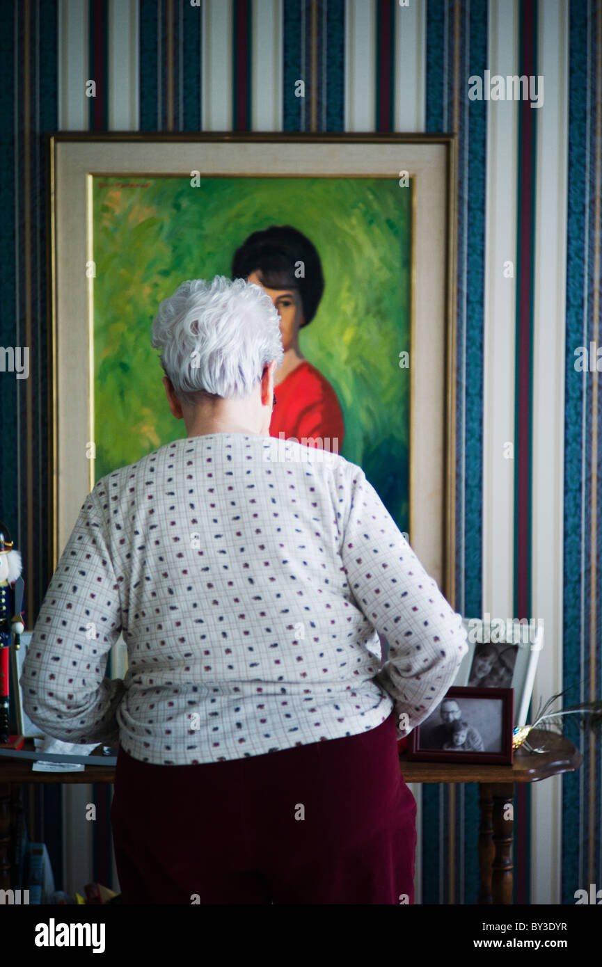Old woman from behind as she looks at portrait of herself as a young ...