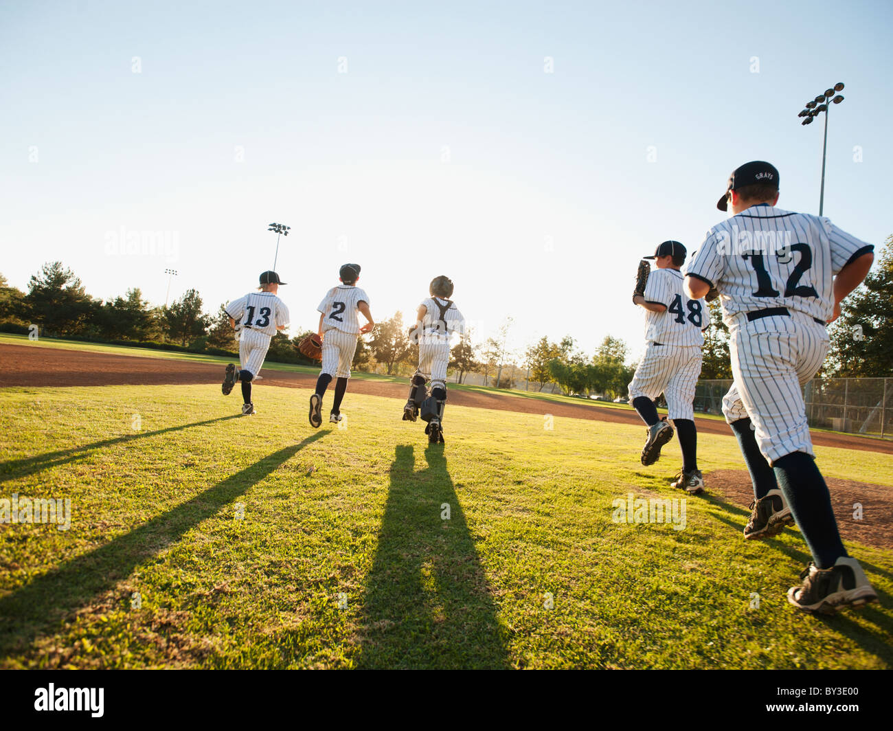 Baseball players (10-11) running on baseball diamond Stock Photo - Alamy
